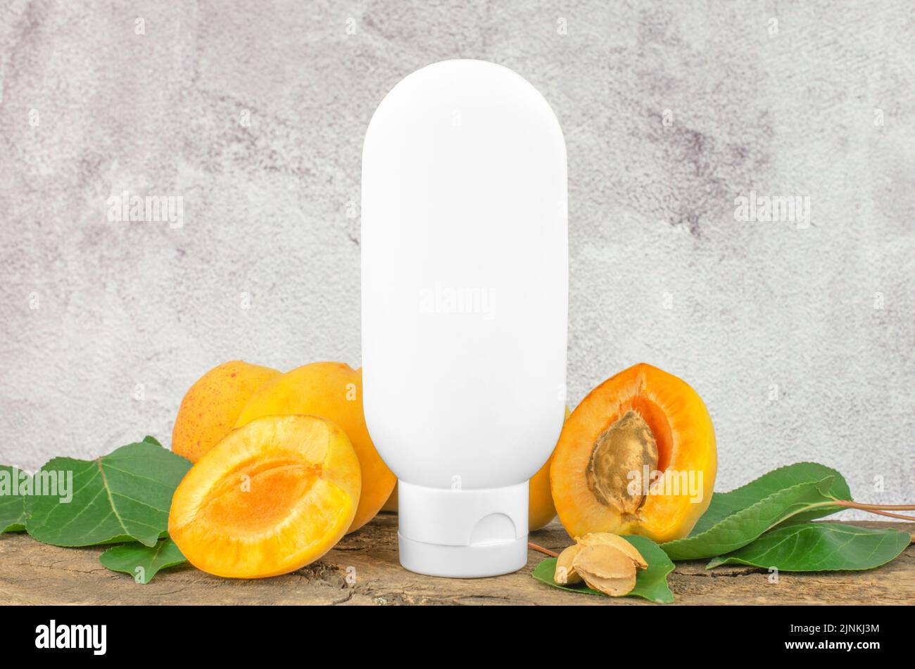 Empty white plastic tube and fresh apricots. Natural cosmetics brand ...