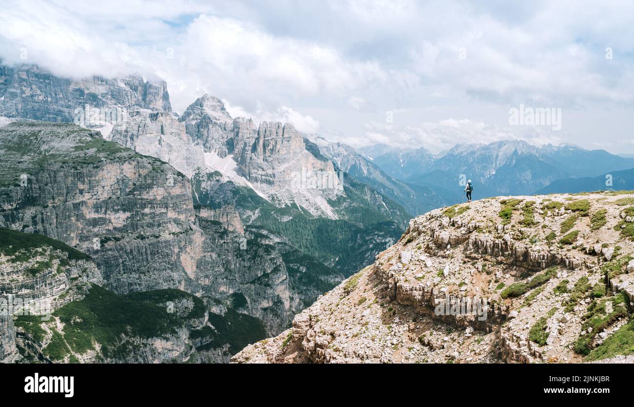 Small woman trekker silhouette with a backpack on the huge picturesque ...