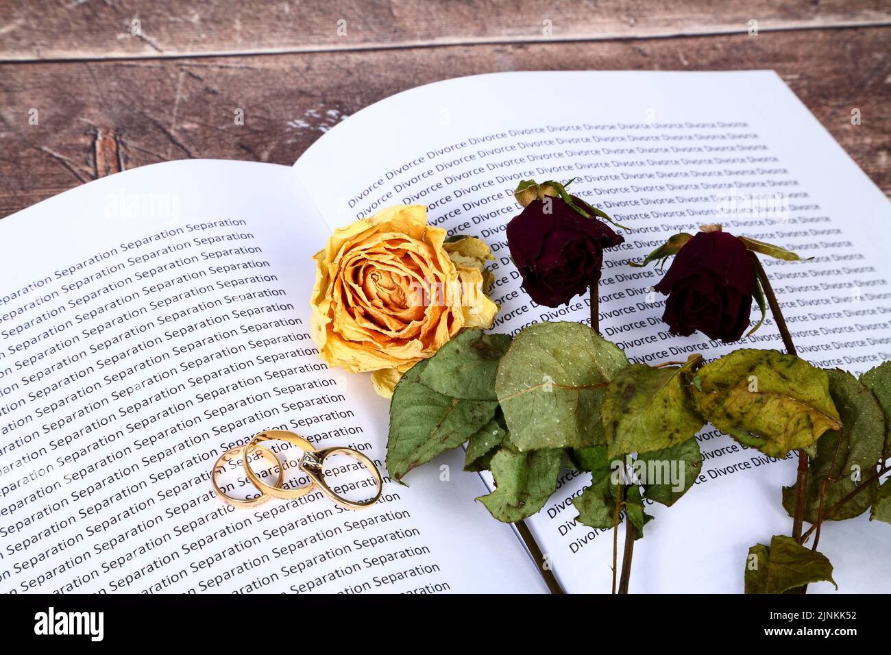 Dead wilted roses laid on a book with the words Divorce and Separation ...