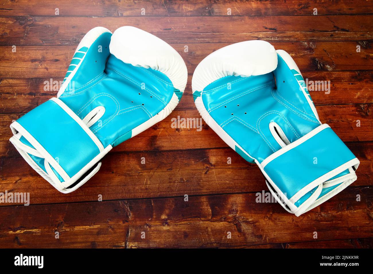 Two blue boxing glove isolated on a wooden background Stock Photo - Alamy