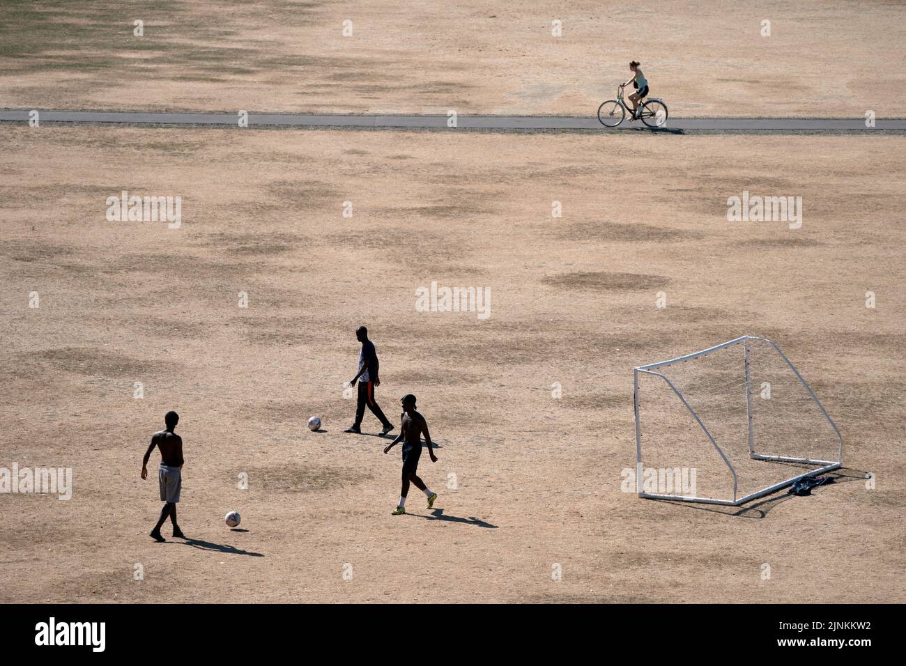 People play football on parched grass on Parker's Piece in Cambridge ...