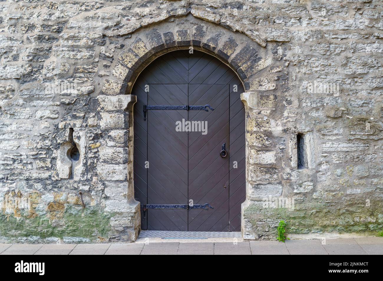 Old metal door in medieval castle facade Stock Photo - Alamy