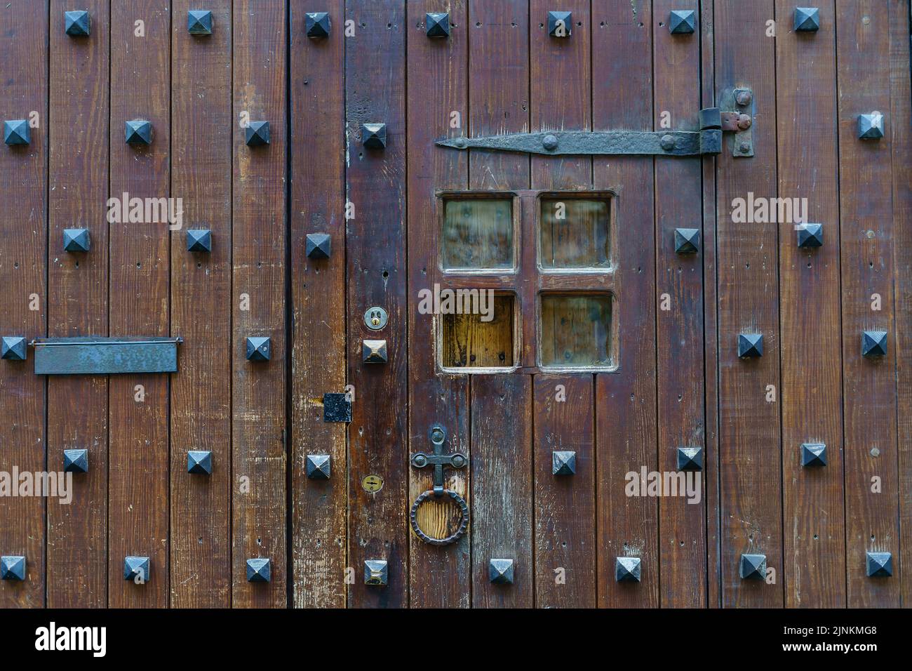 Old medieval door with metal trim and small peephole window Stock Photo ...