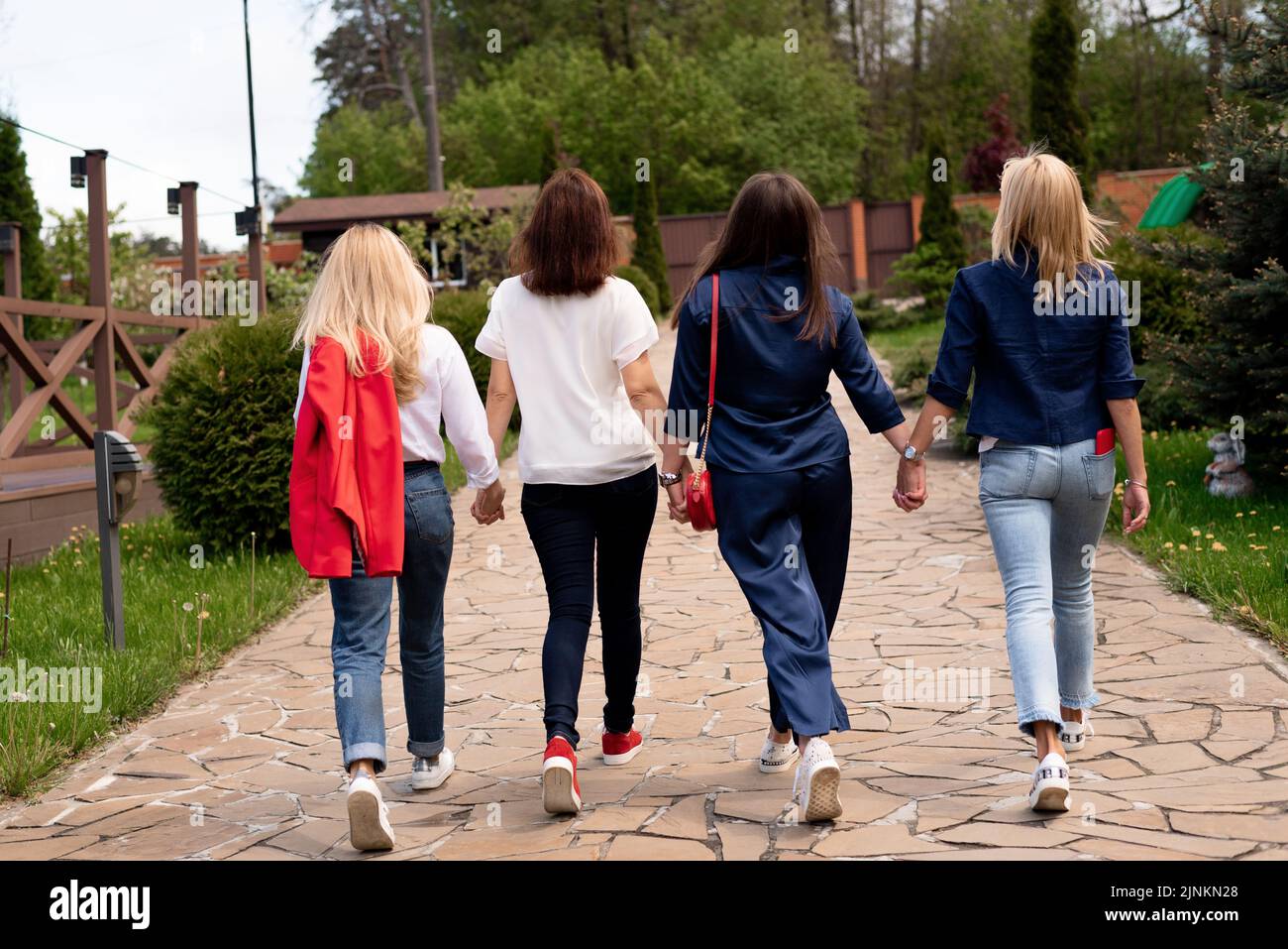 four women - girlfriends go forward, rear view Stock Photo - Alamy