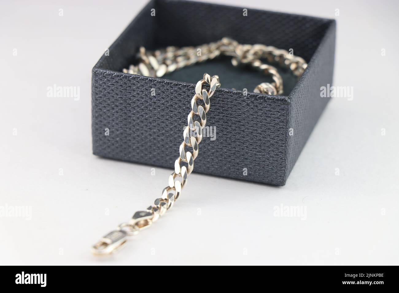Silver chain with details of chain links out of the box that is worn as ...