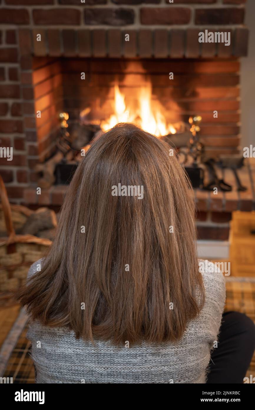 Woman from behind sitting on the floor in front of the comfortable ...