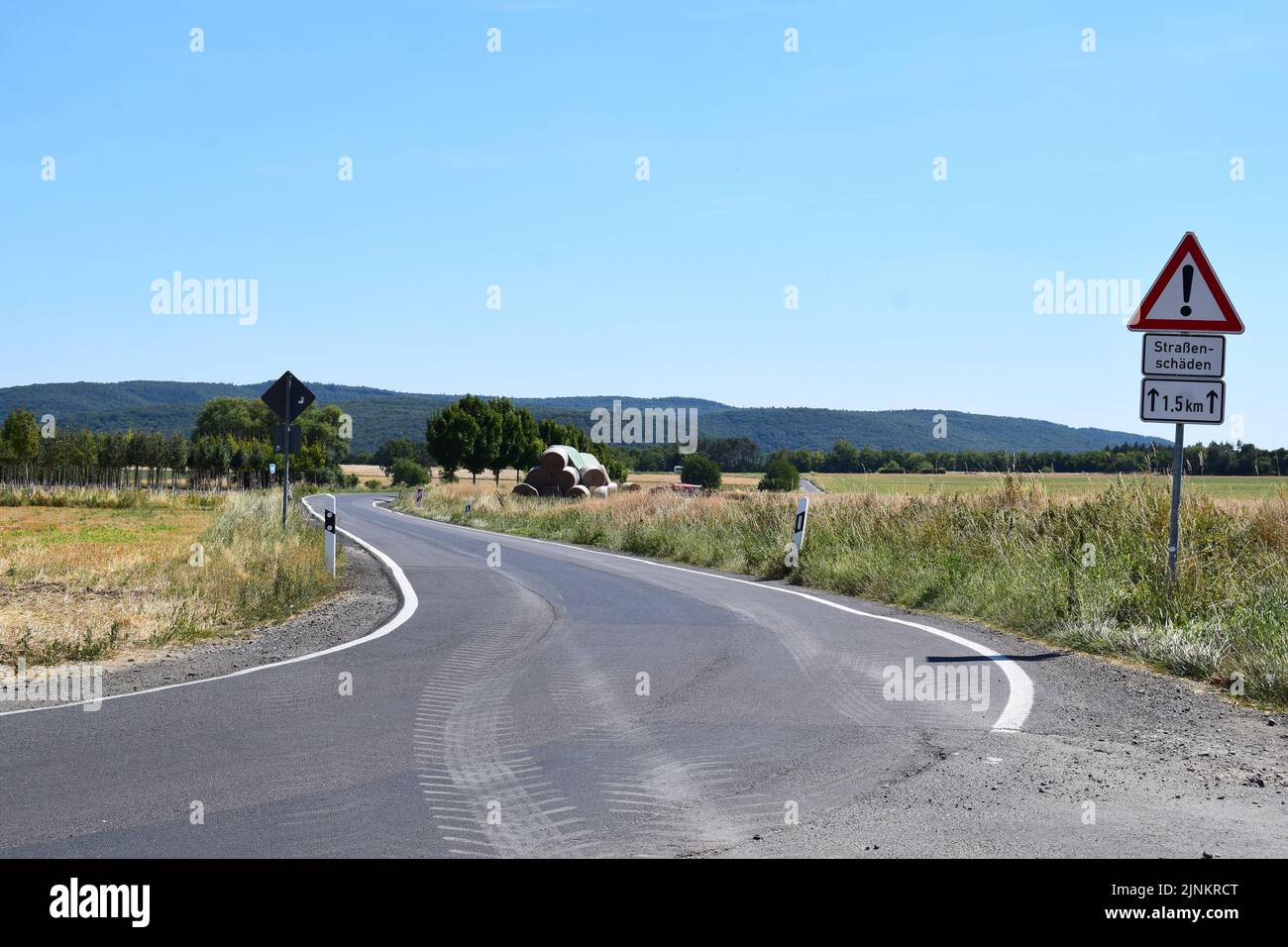 bad road with a warning sign Stock Photo - Alamy