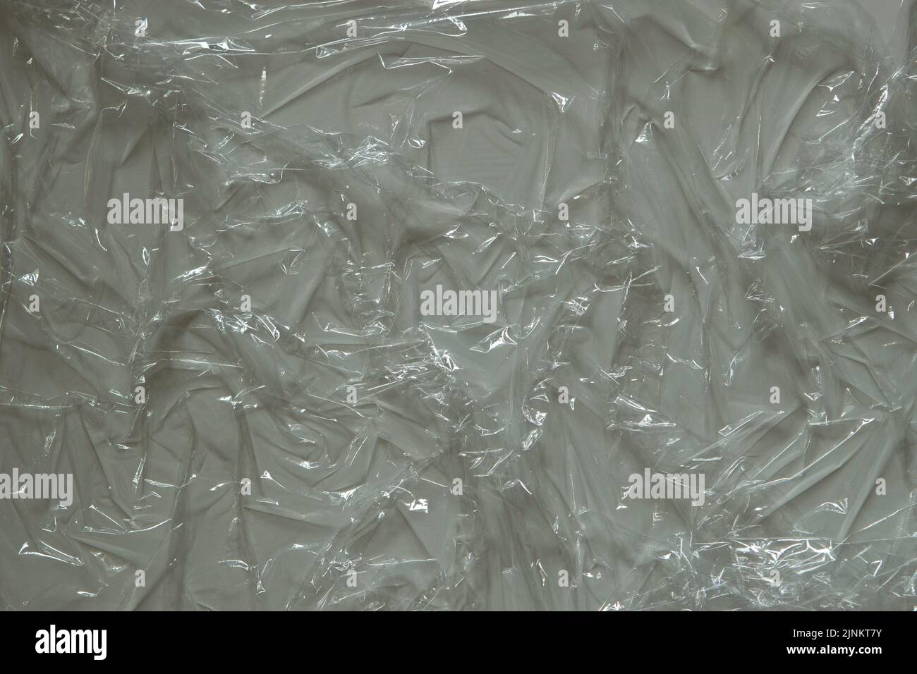 Wrinkled plastic wrap on gray color background. Crumpled transparent ...