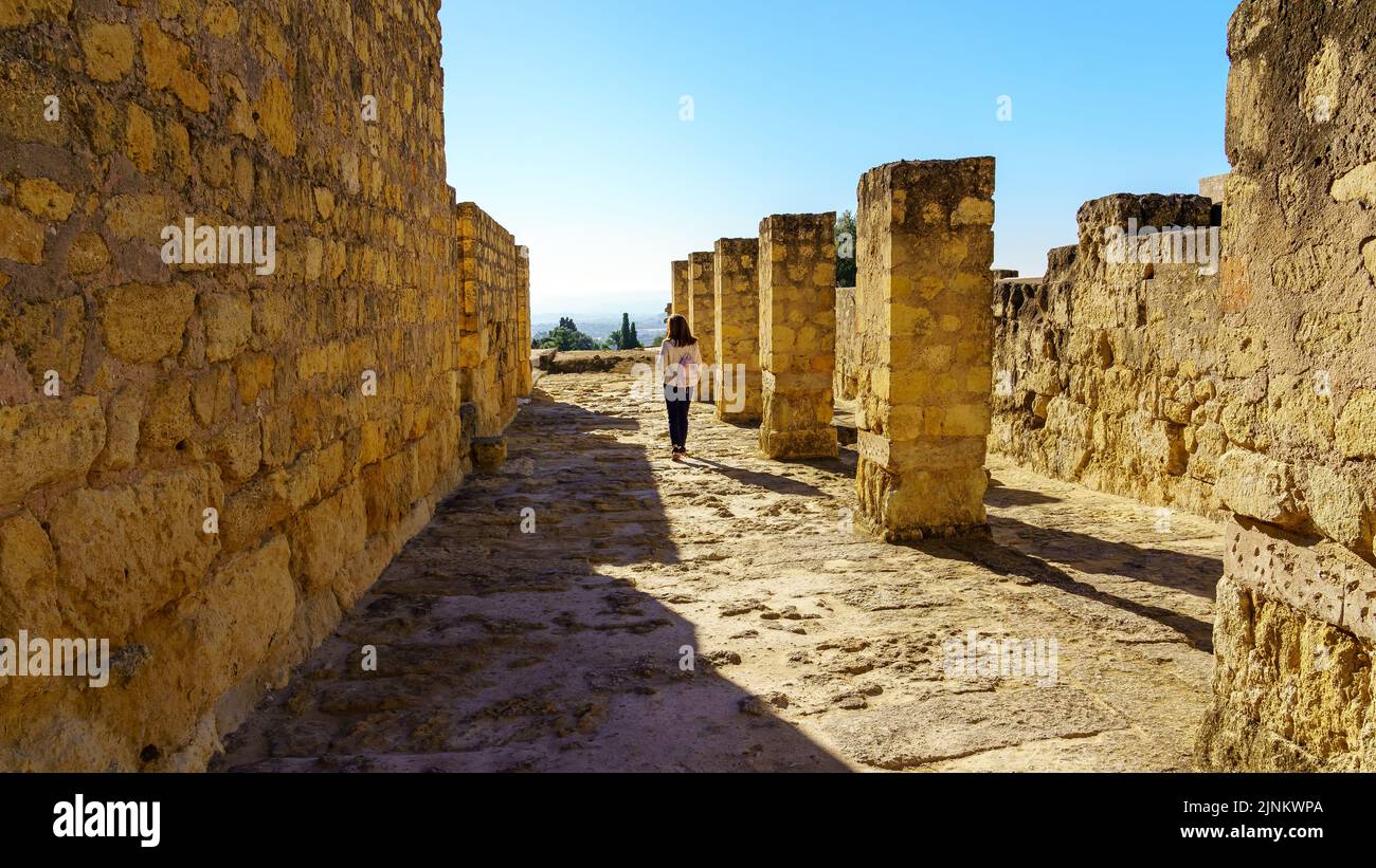 Woman walking through the archaeological ruins of the ancient Arab city ...