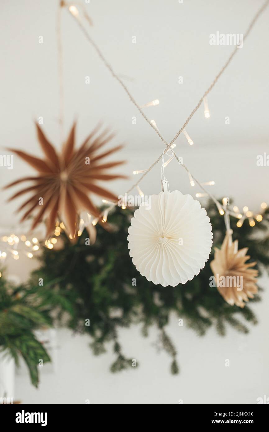 Stylish paper christmas stars and lights hanging on background of ...