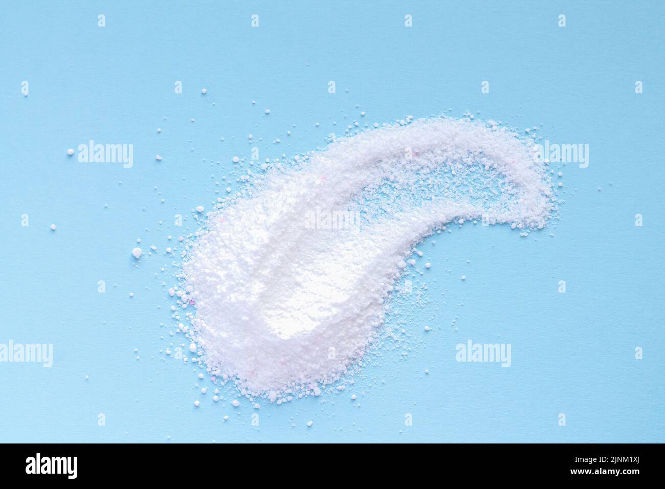 White washing powder pile on blue background Stock Photo - Alamy