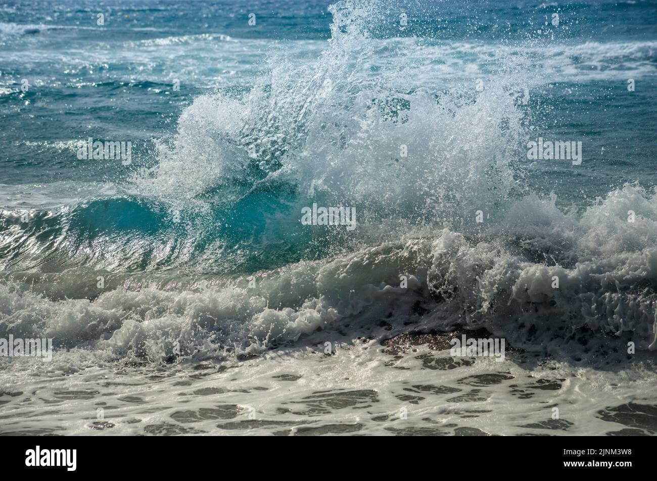 Wave splashing on a beach with crystal clear blue waters in Cabo de ...