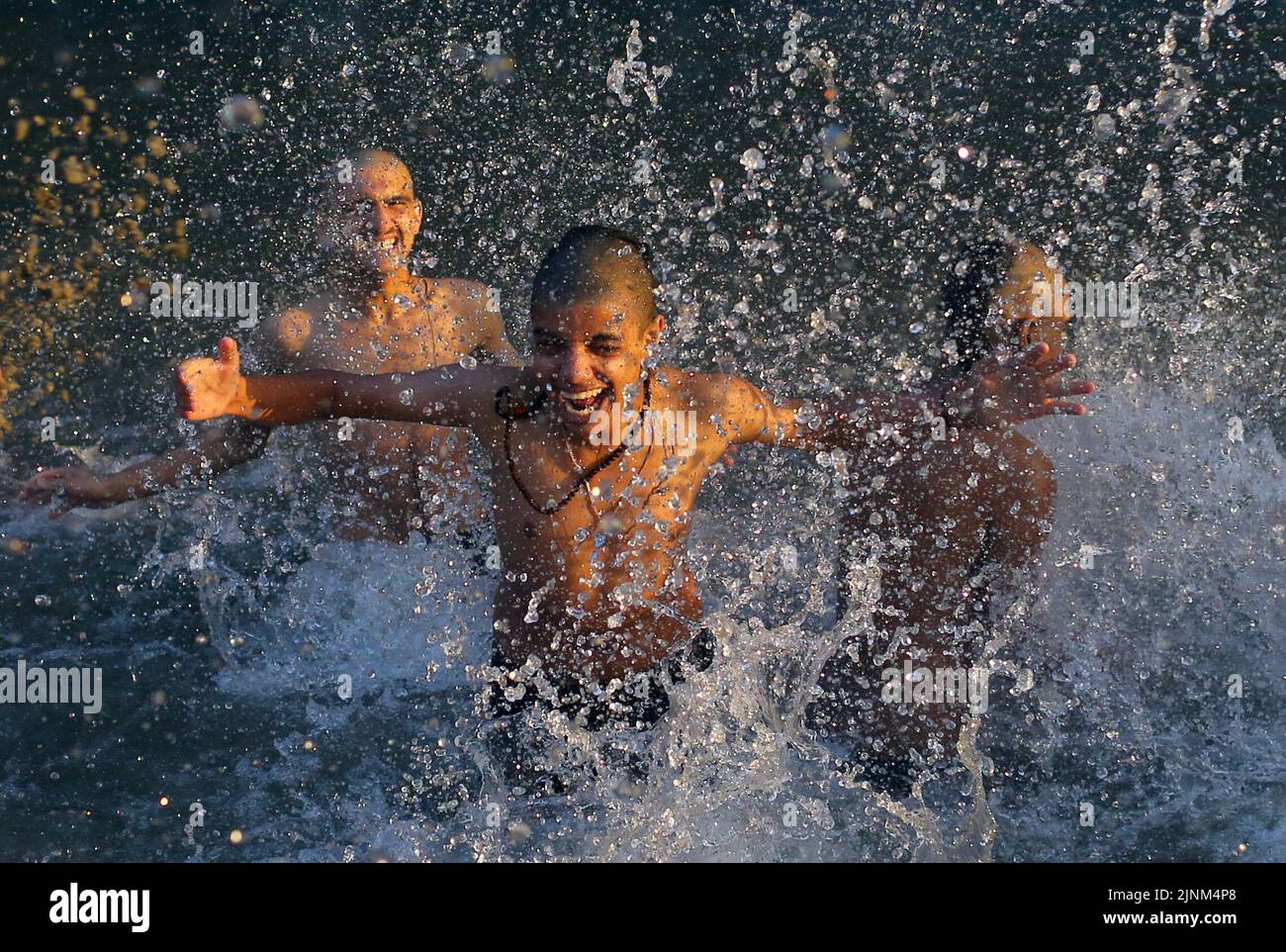 Kathmandu, Nepal. 12th Aug, 2022. A Hindu priest splash water while he ...