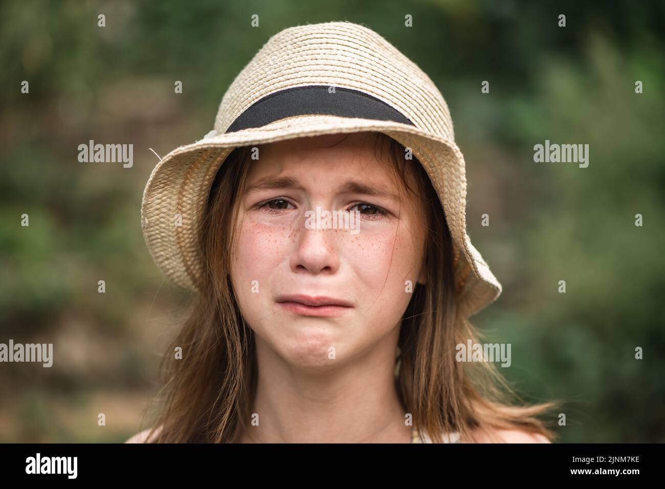cute girl in a hat is sad and crying Stock Photo - Alamy