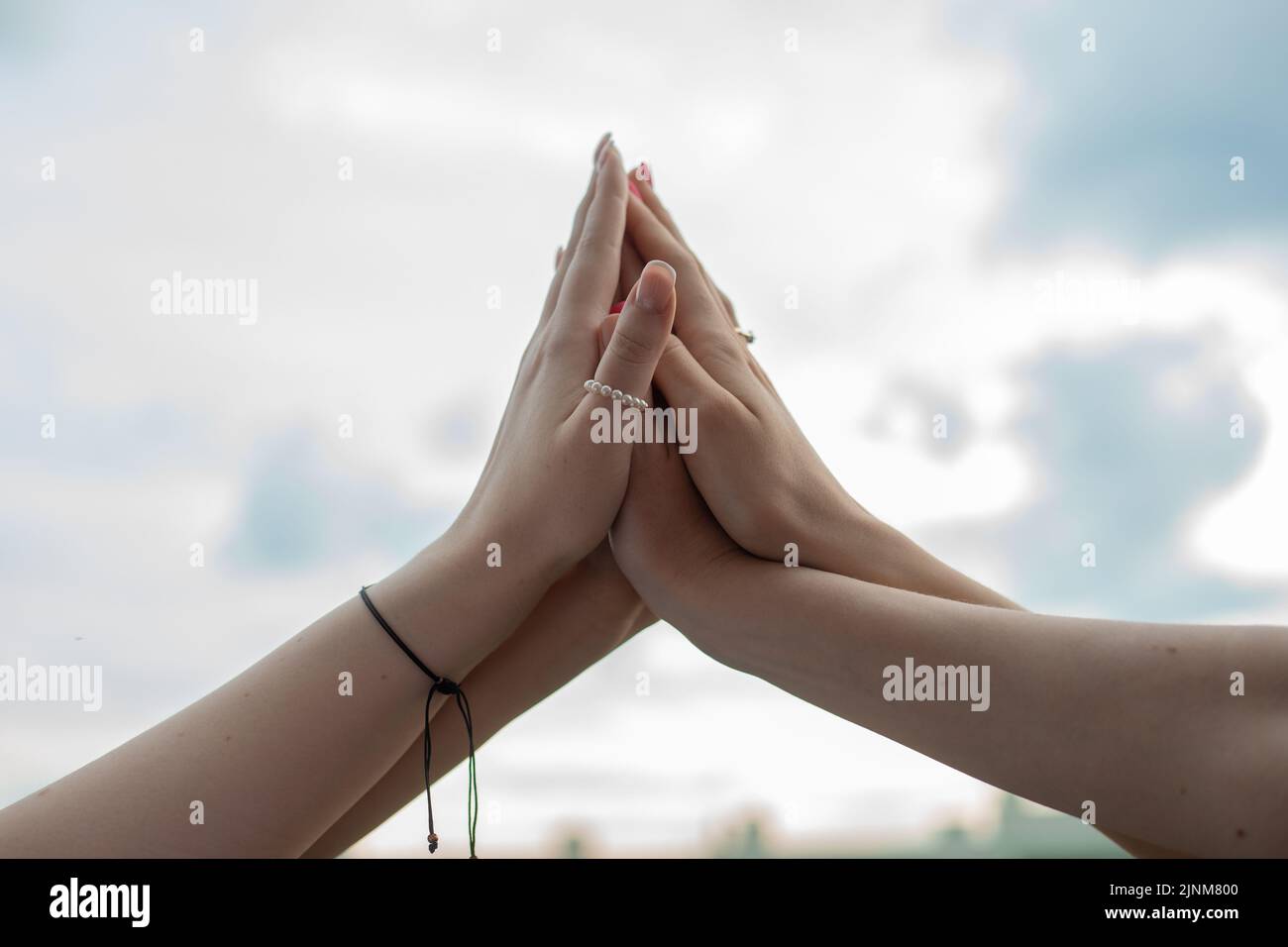 Cropped photo of young women folding hands, giving high five, clapping ...