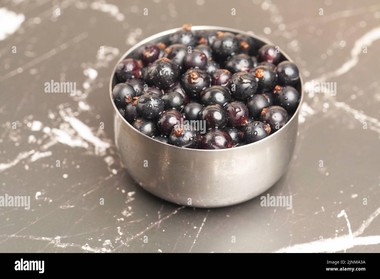 Black currants in a metal bowl Stock Photo - Alamy