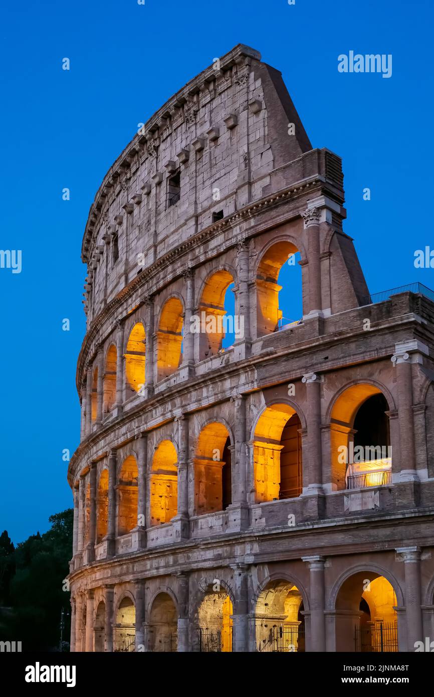 Side view of the facade of the Colosseum at dusk, with the illuminated ...