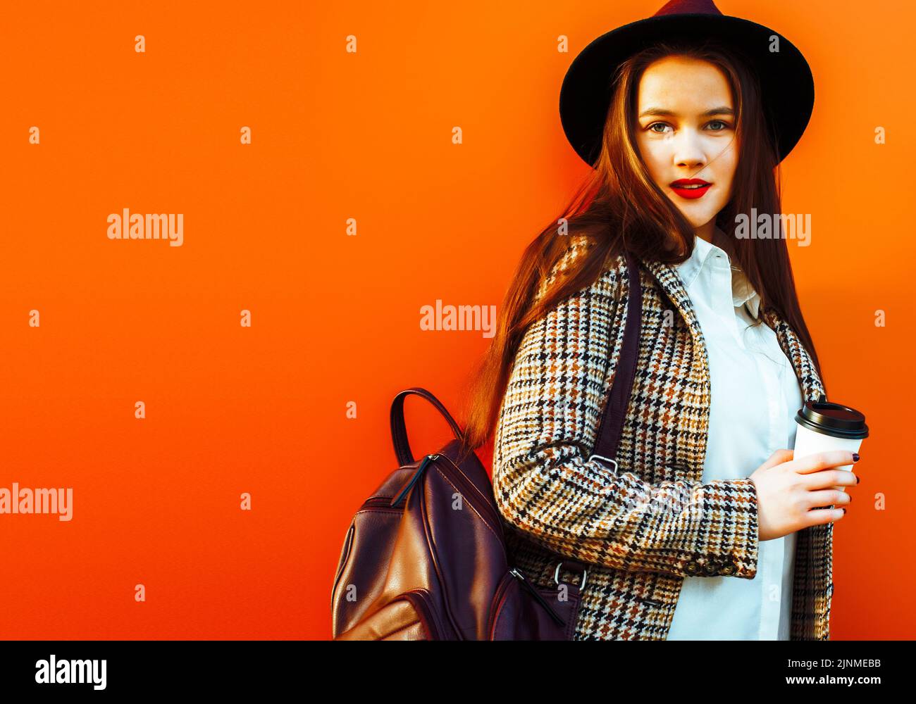 young pretty brunette business woman posing against modern building in ...