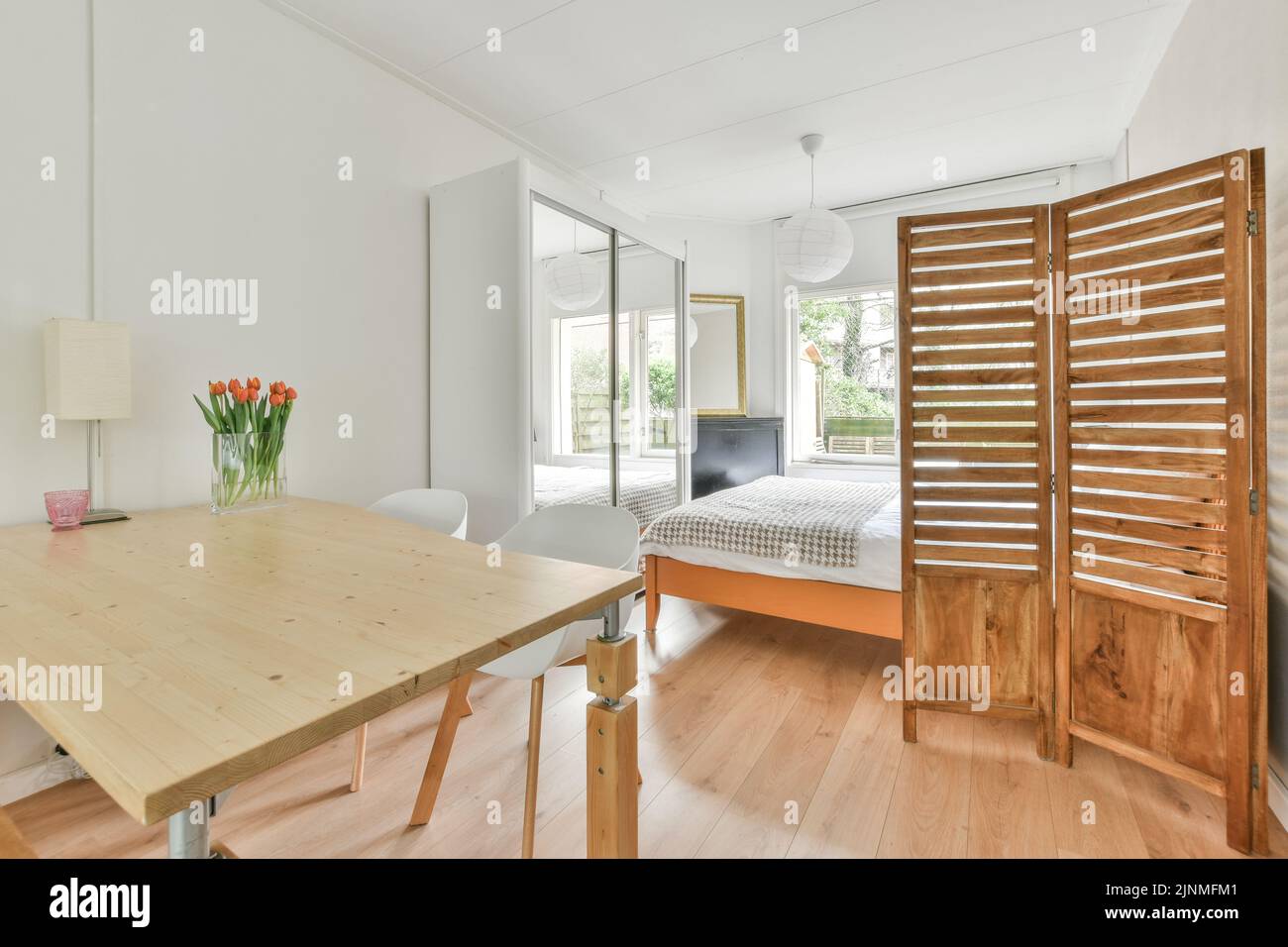 Comfortable bed and dining table in spacious bedroom with interior in ...