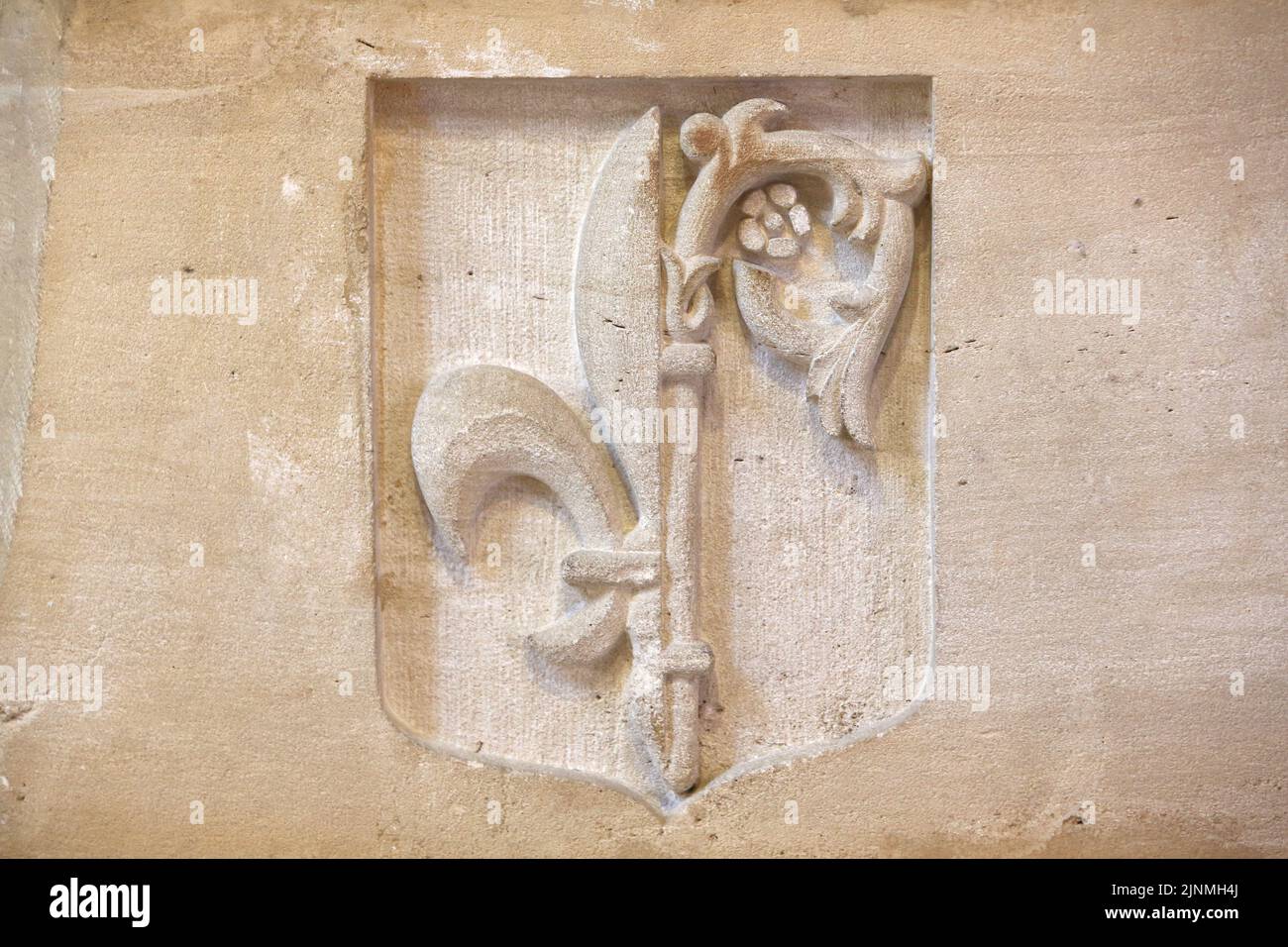 Fleur de lys. Armoirie sculptée sur un la façade d'un mur en pierre ...