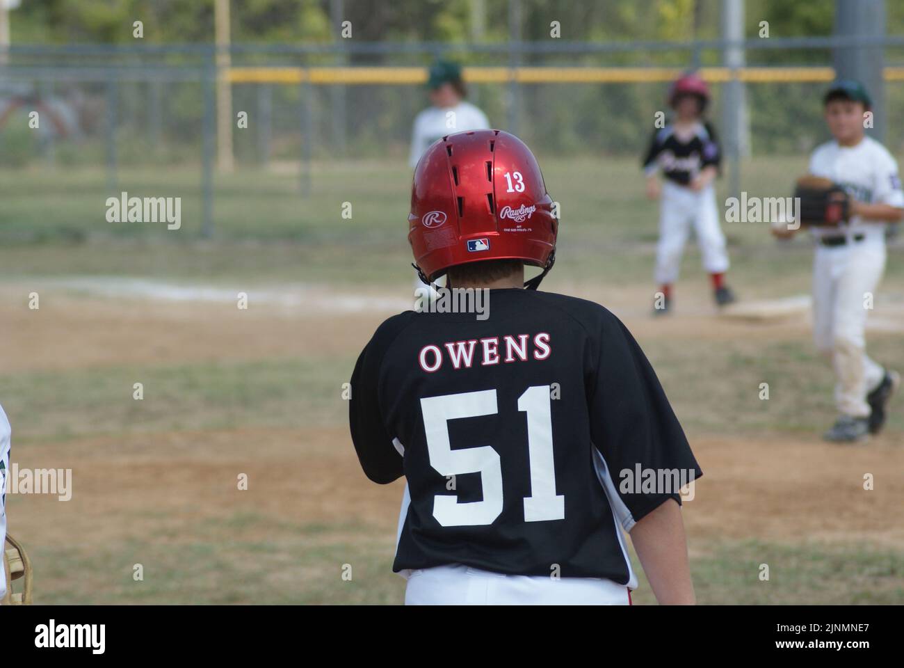 Young baseball player waiting at third base Stock Photo - Alamy