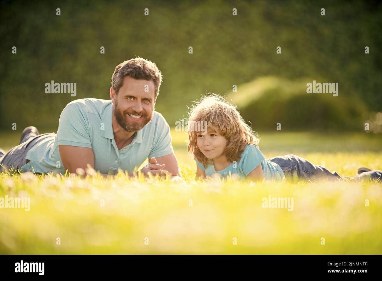 happy family of daddy and son kid relax in summer park green grass ...