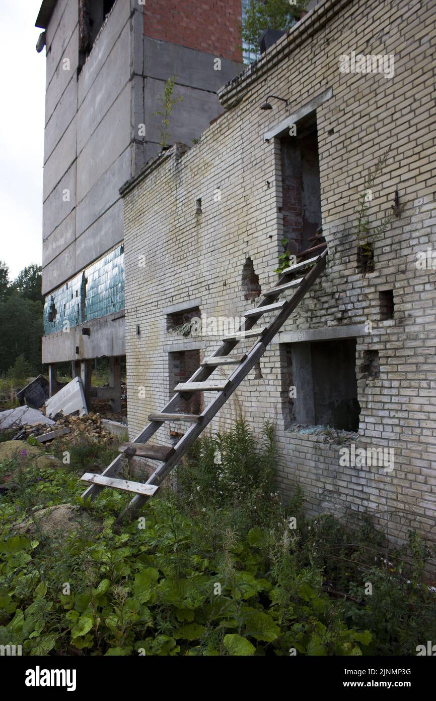 wooden staircase to the second floor of a destroyed industrial brick ...