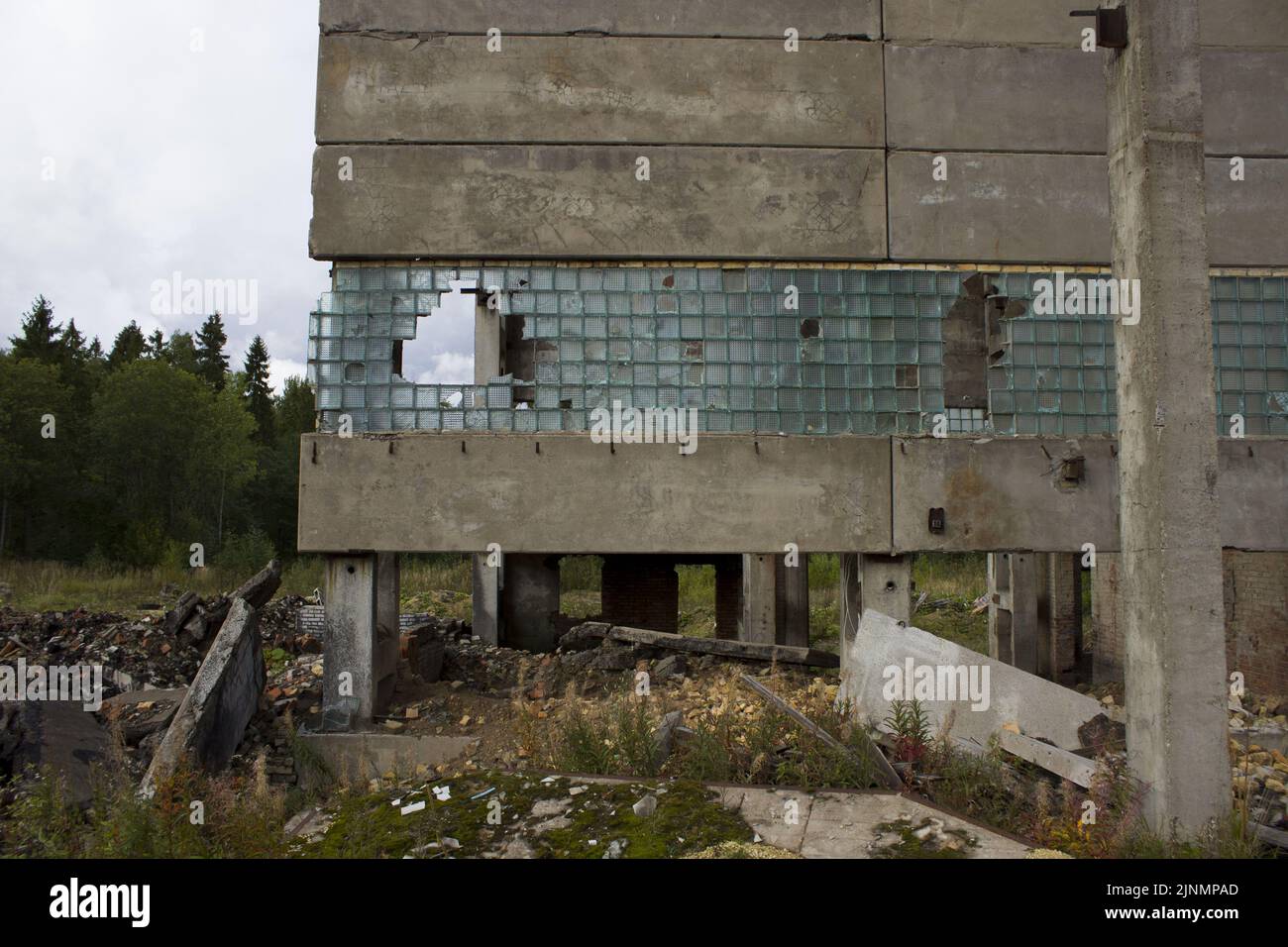 ruined industrial building on stilts with a broken wall of glass ...