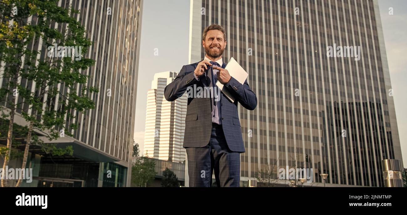 happy successful man in formalwear with computer outside the office ...