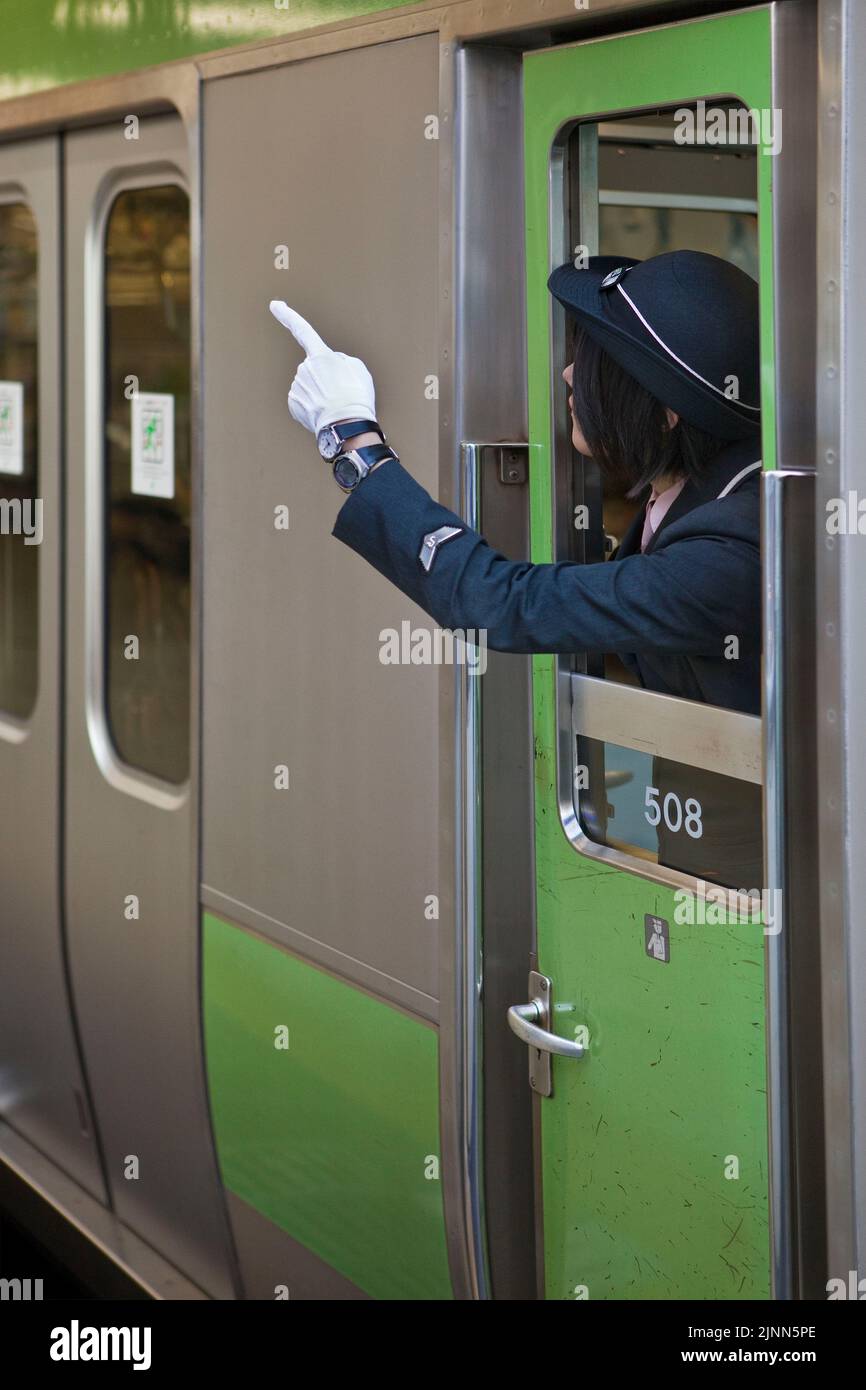 JR female train conductor signals Shinagawa Tokyo Japan Stock Photo - Alamy