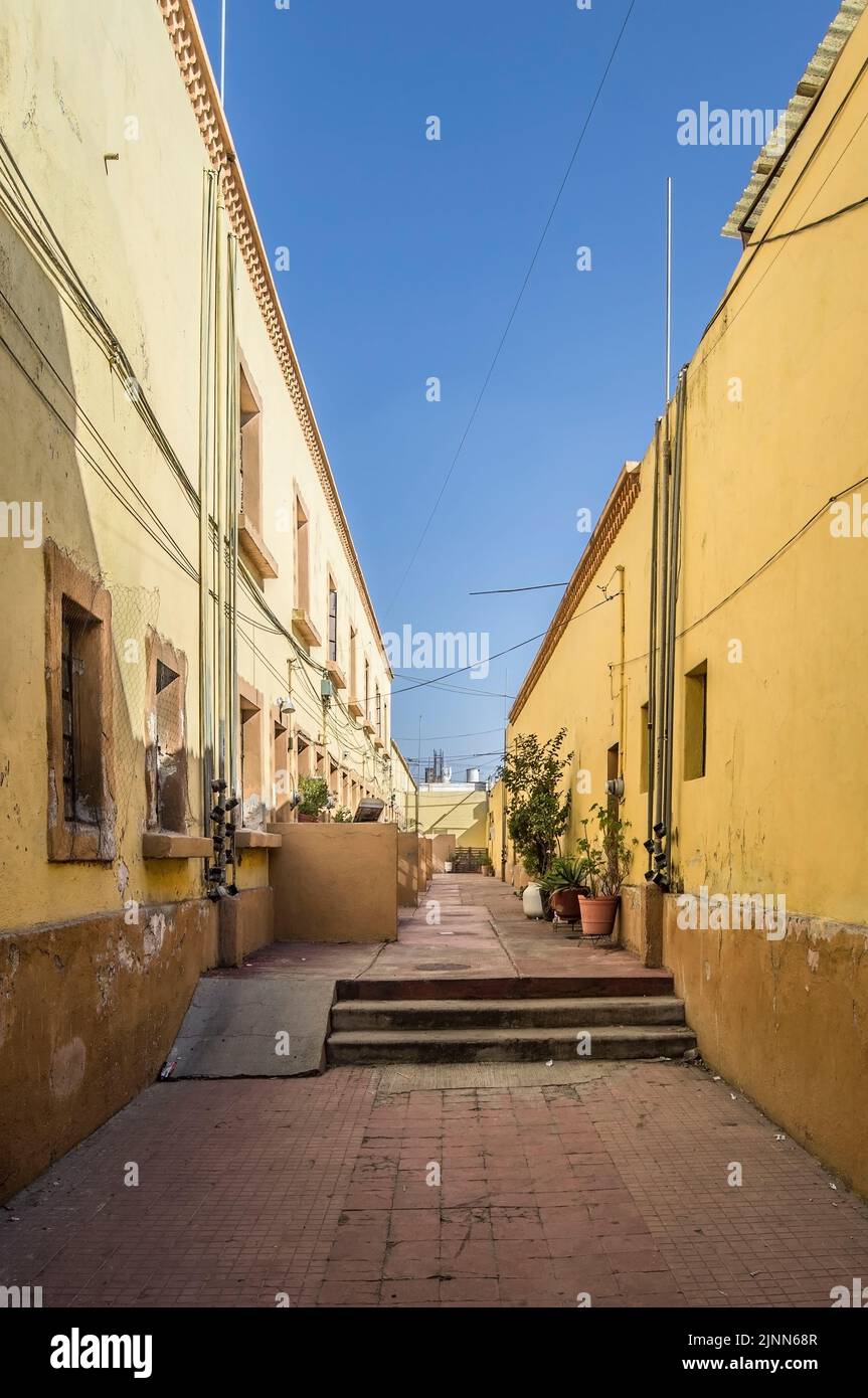 central courtyard of a neighborhood, yellow houses with brick, stairs ...