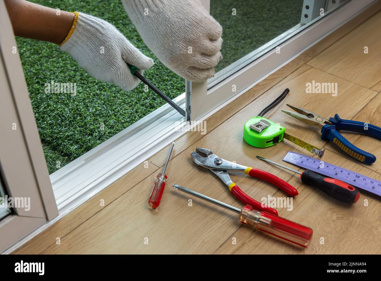 Worker fixing the insect screen sliding door Stock Photo - Alamy