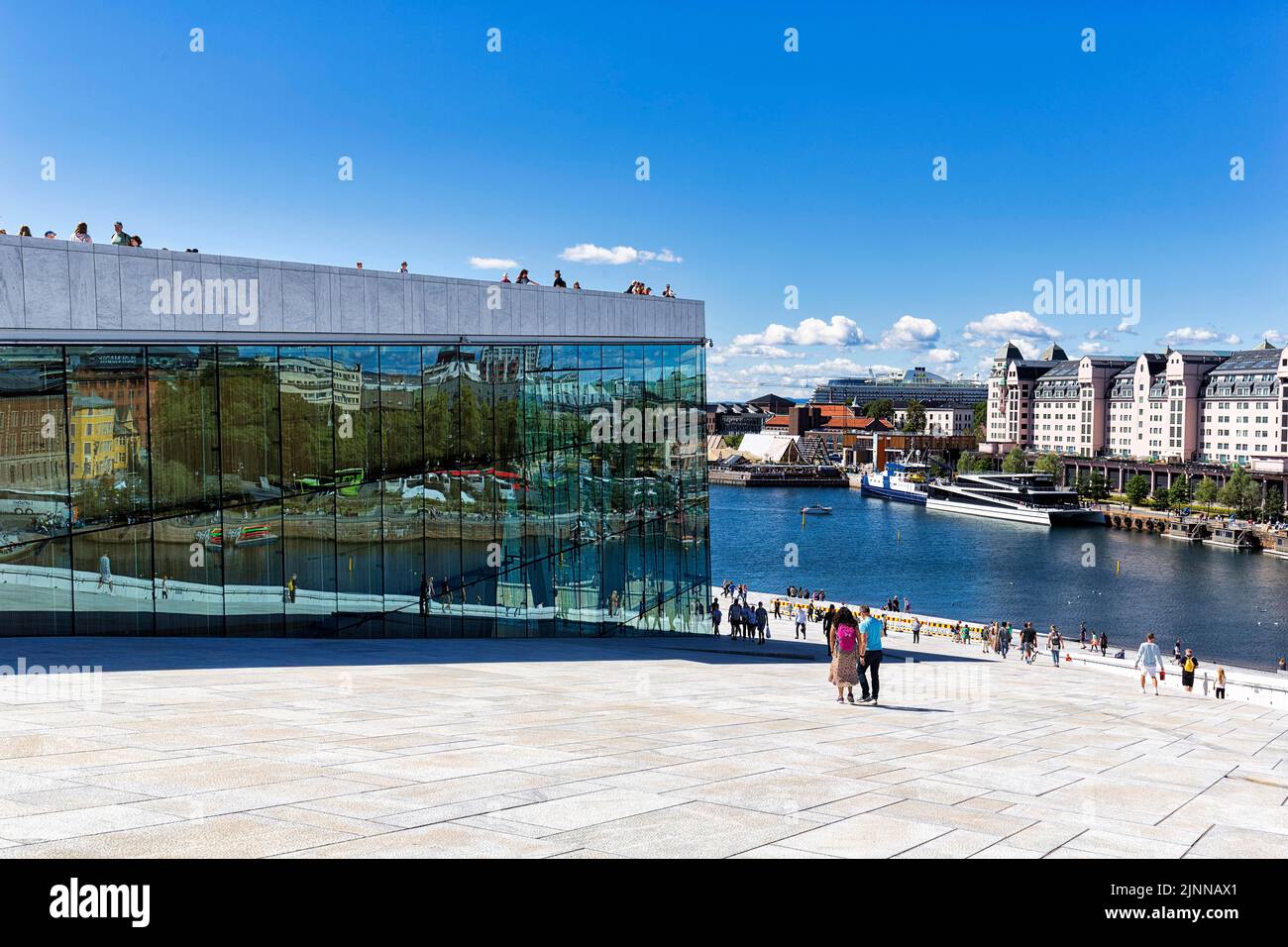 Pedestrians on the white forecourt and roof of the opera house ...