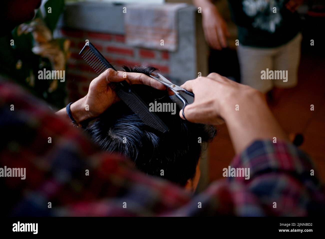 Barber man cut the young man hair with scissors Stock Photo - Alamy