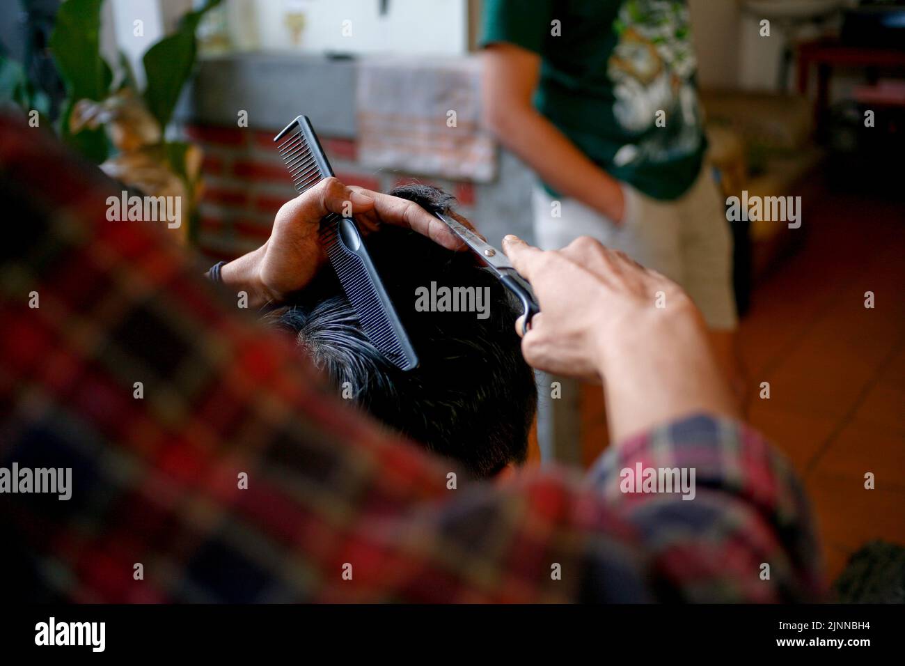 Scissors cut the young man hair Stock Photo - Alamy