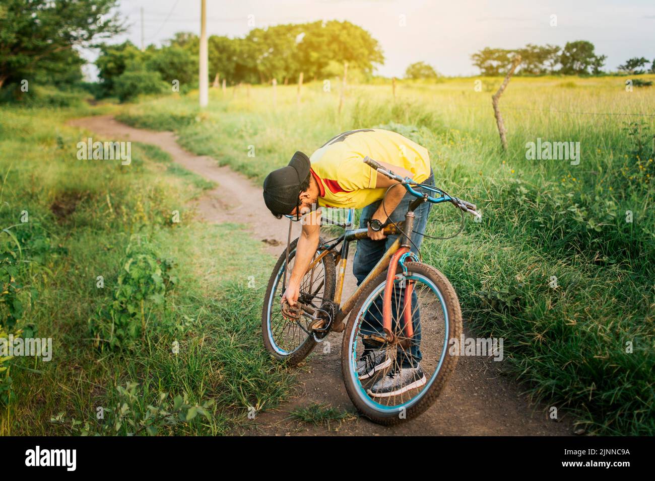 Man repairing his bike in the middle of the road, Man in the ...