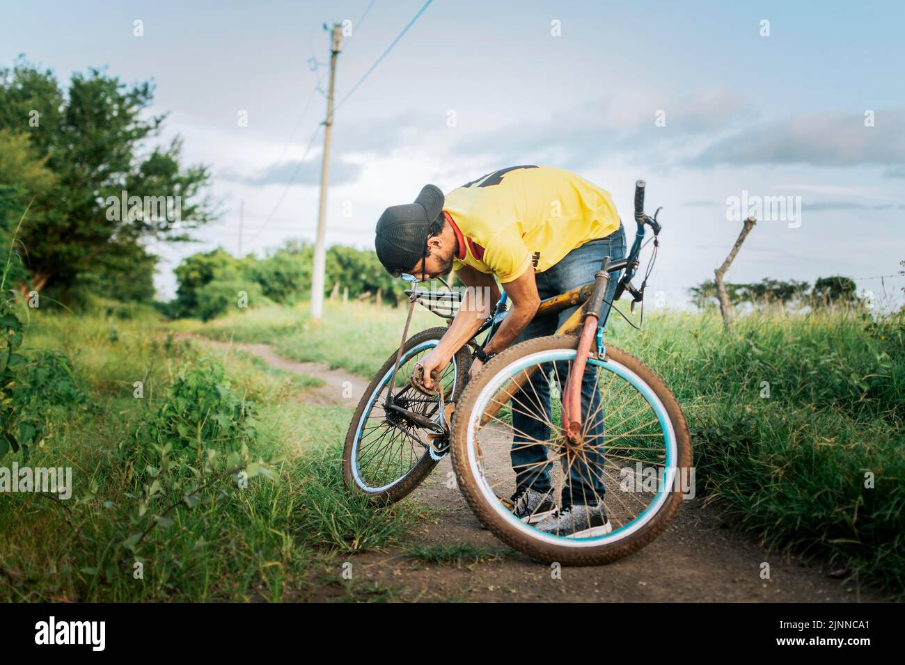 Man in the countryside repairing his bike, Traveler person repairing ...