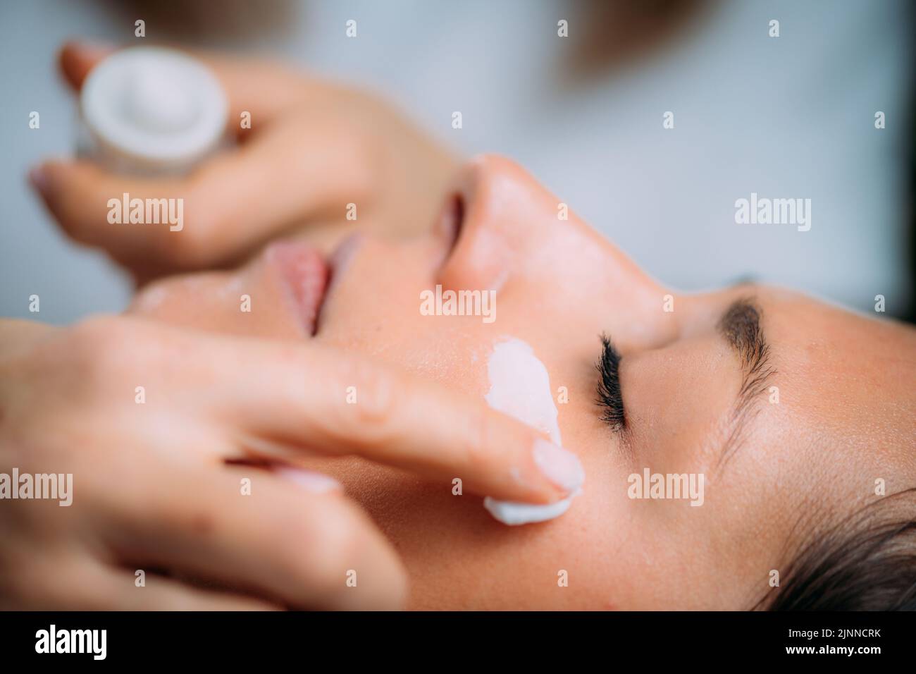 Beautician applying facial treatment cream hi-res stock photography and ...