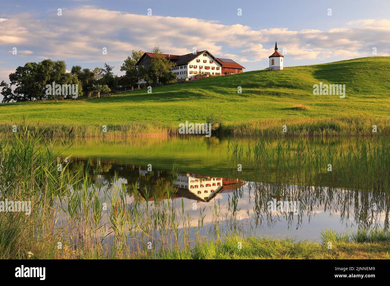 Lake chapel and farmhouse reflected in the lake, Hergatsried Lake ...