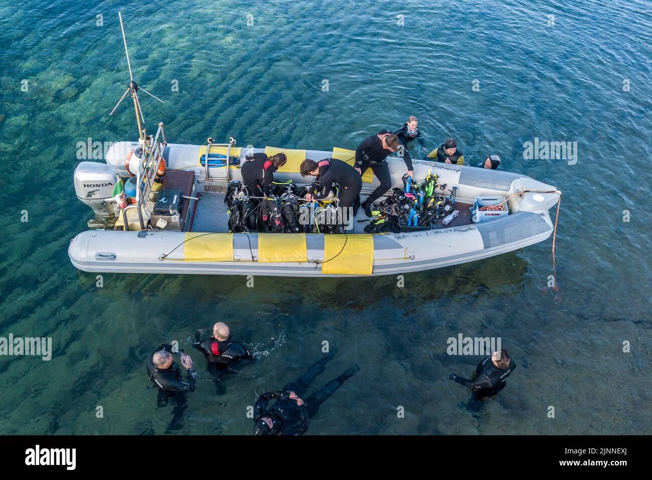 Aerial view of the dinghy for scuba divers, in front of it divers ...