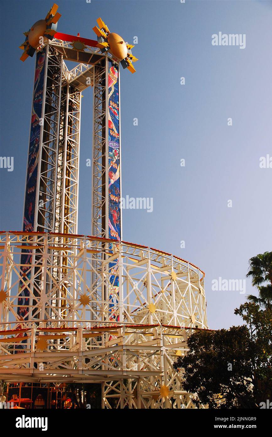A large drop ride stands in the center of a circling roller coast at ...