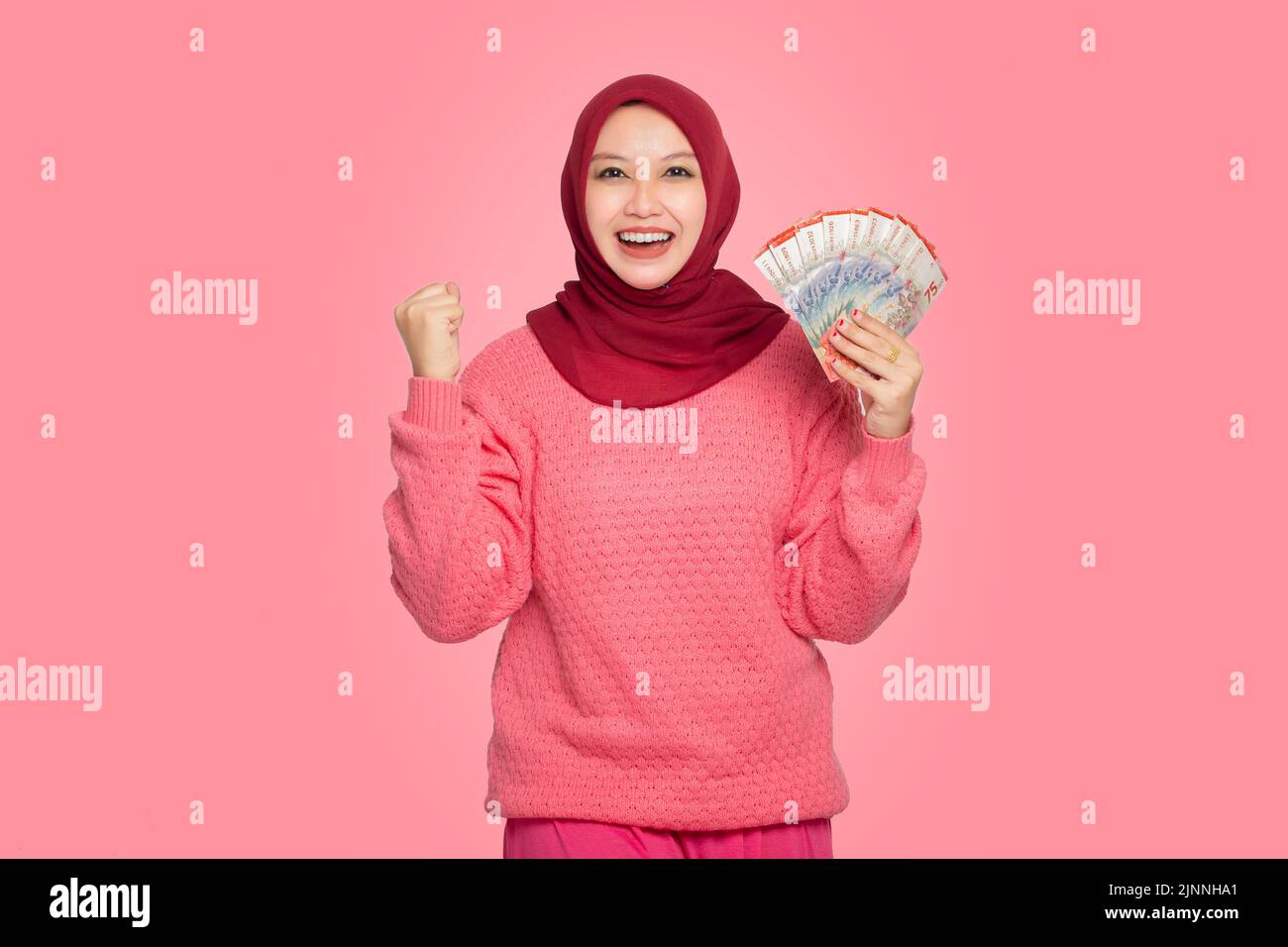 Portrait of the happiest Indonesian Muslim woman holding rupiah money ...