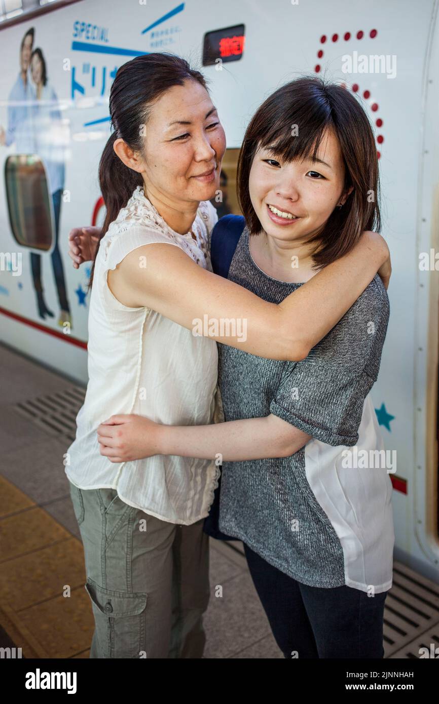 Mother greets arriving teenage daughter at Shinkansen station in Tosu ...