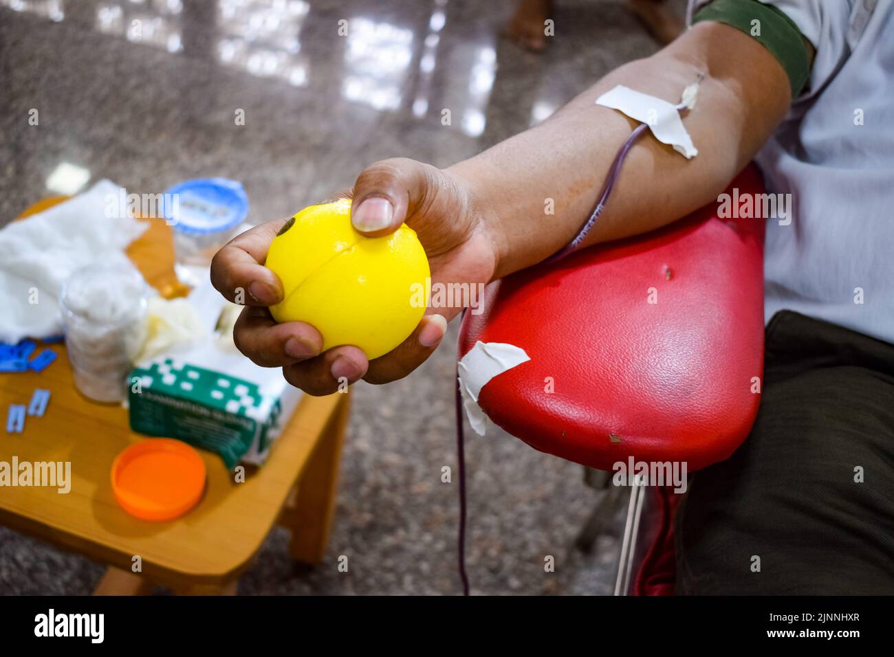 Blood donor at Blood donation camp held with a bouncy ball holding in ...