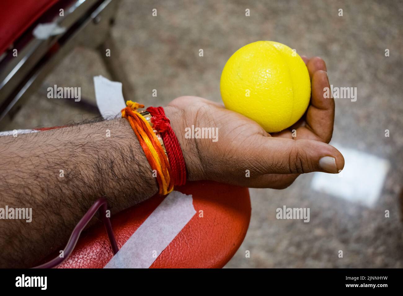 Blood donor at Blood donation camp held with a bouncy ball holding in ...