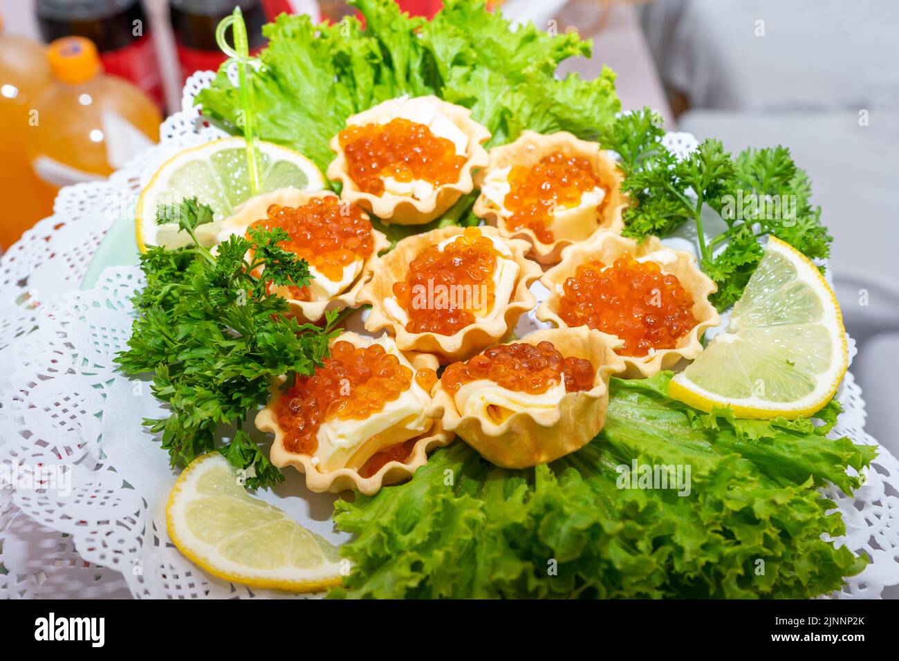 Red caviar and grated cheese in small dough baskets. A delicious cold ...