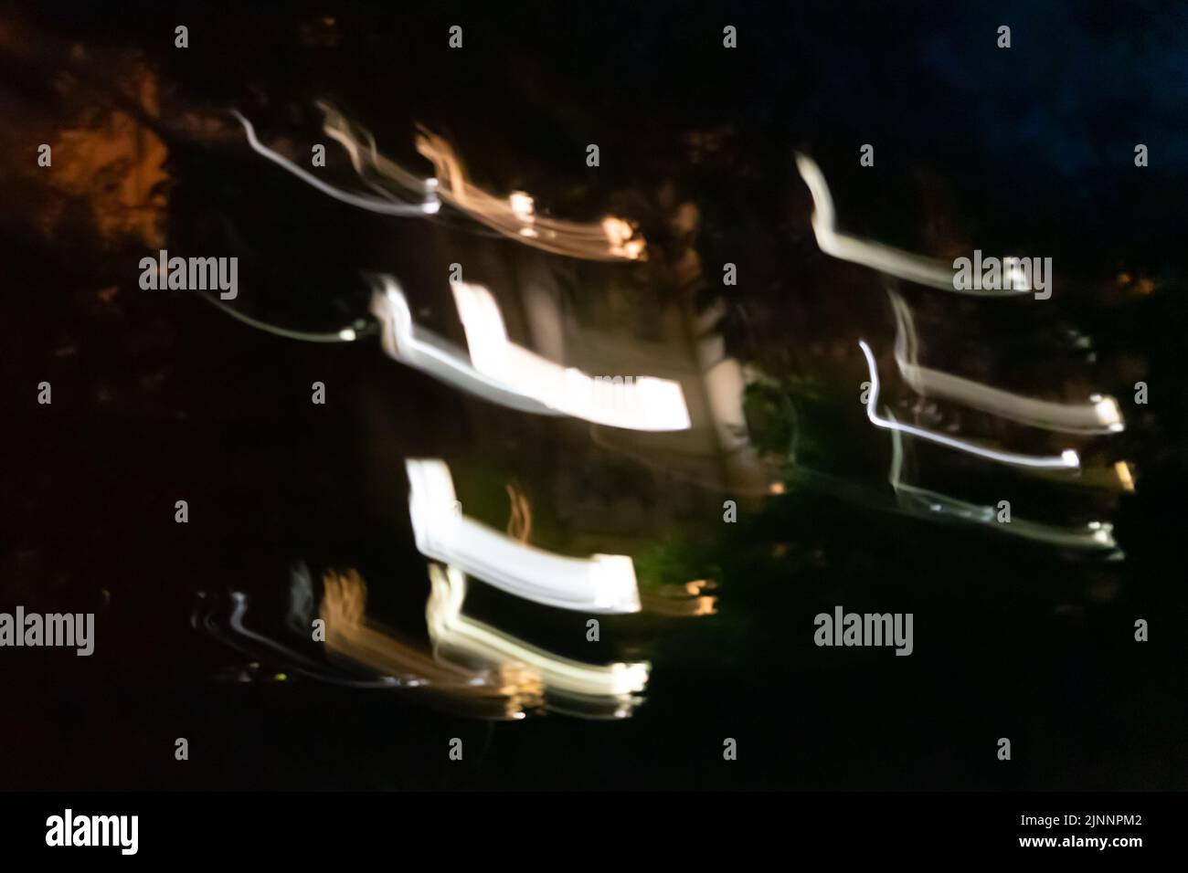 Close up shot of Several different colored lines moving in the dark ...