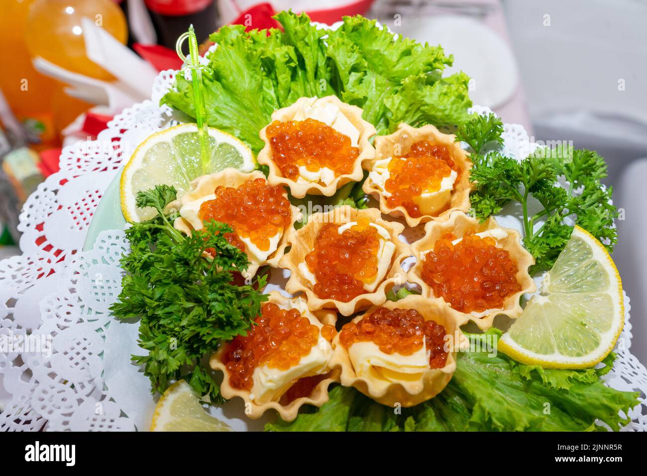Red caviar and grated cheese in small dough baskets. A delicious cold ...