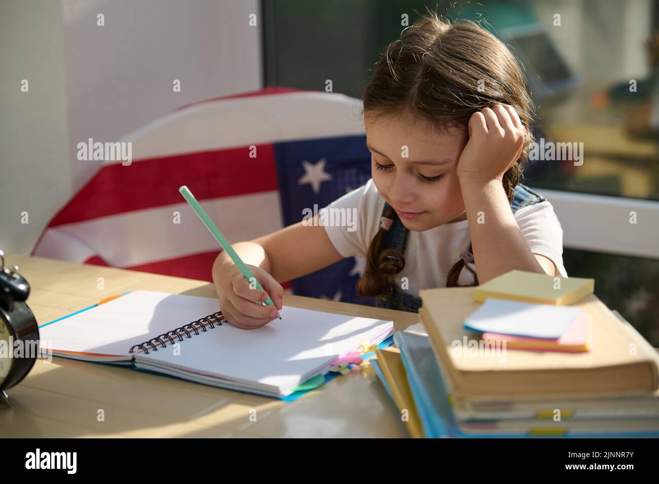 Beautiful Caucasian kid, schoolgirl, first grader sitting on a chair ...