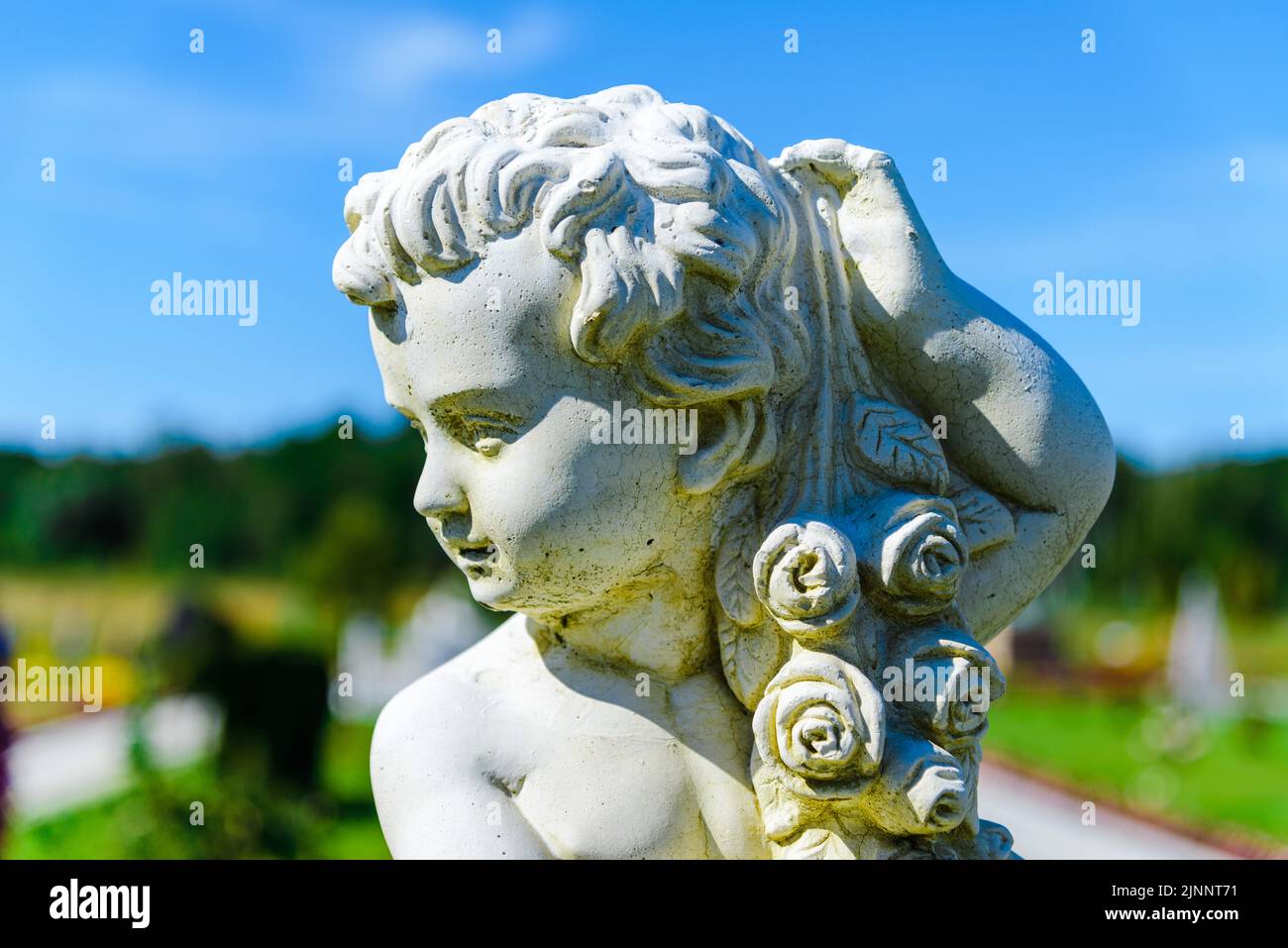 Closeup of a ancient young boy statue at summer park.Close-up Stock ...